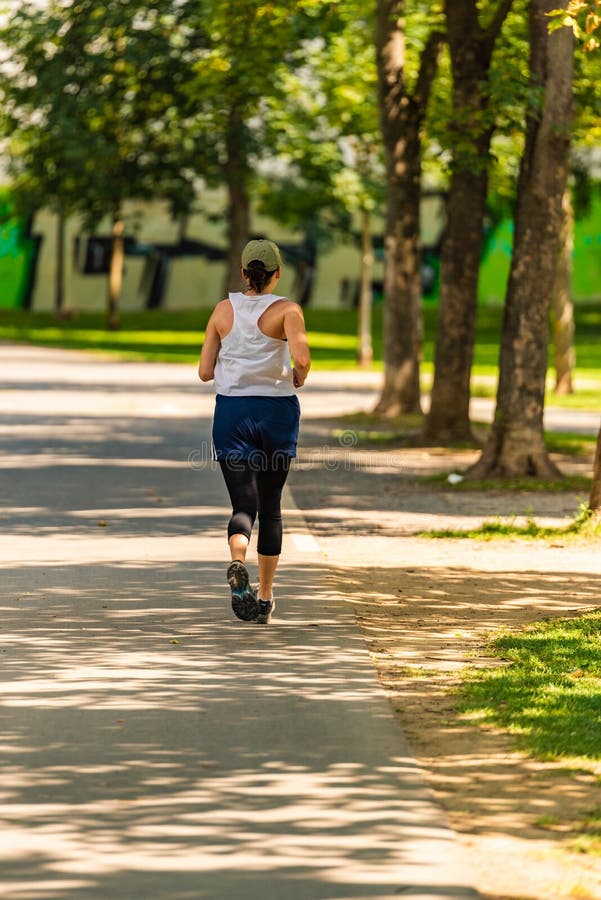 Young Woman Jogging Along Path in Park Editorial Photography - Image of ...