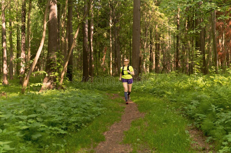 Young Woman Jogging on a Path in a Natural Forest Park Stock Photo ...