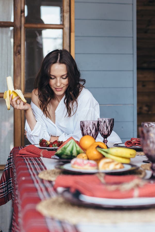 Young Woman at the Kitchen Table Eating Fruit Stock Photo - Image of ...