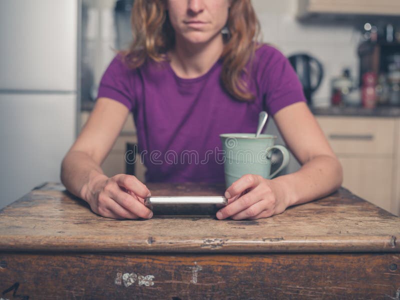 Young Woman in Kitchen with Tea and Smart Phone Stock Image - Image of ...
