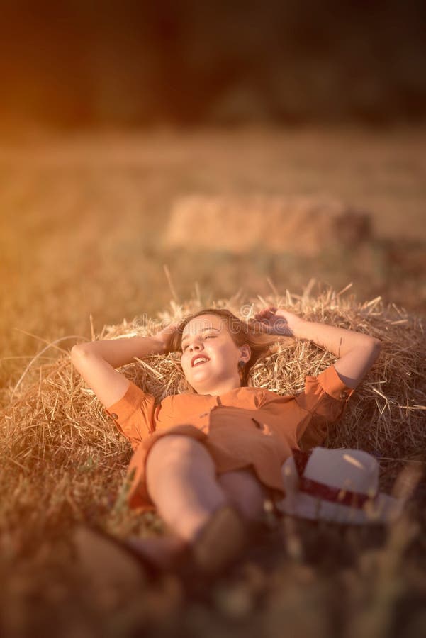 Young woman laying in hay stock photo. Image of beautiful - 185786560