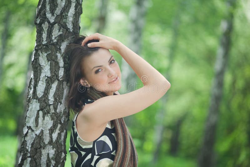 Young Woman Leaning Against a Tree Stock Photo - Image of happy, park ...
