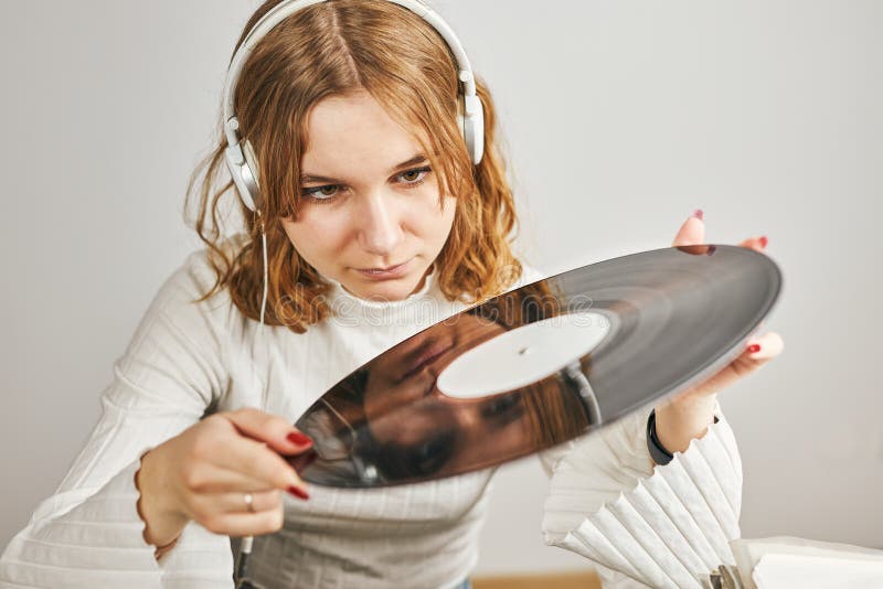 Young Woman Listening To Music From Vinyl Record Player Playing Music On Turntable Player Stock