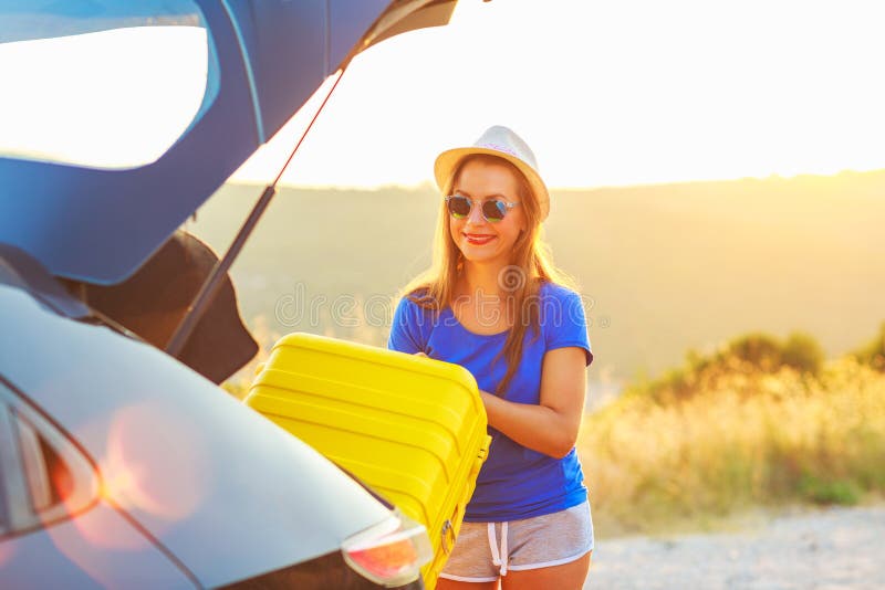 Woman Loading Luggage into the Back of Car Parked Alongside the Stock ...