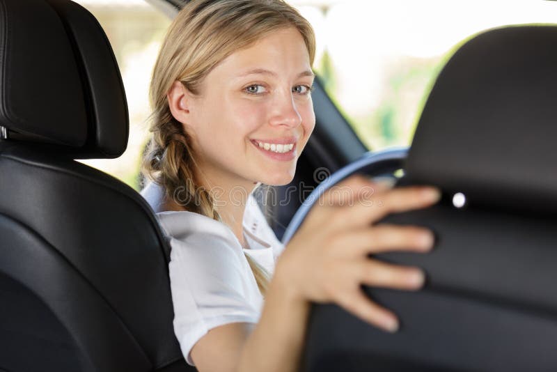 Young Woman Looking Back from Car Drivers Seat Stock Image - Image of ...