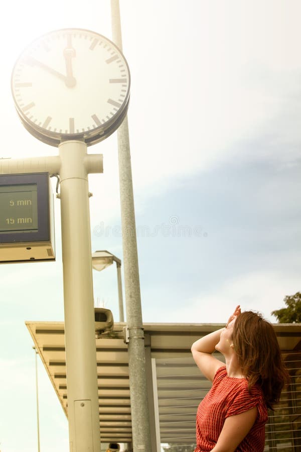 Young Woman Looking at Clock at Train Station Stock Photo - Image of ...
