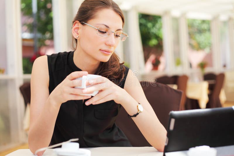 Young Woman Looking at Her Tablet Computer and Drinks C Stock Image ...