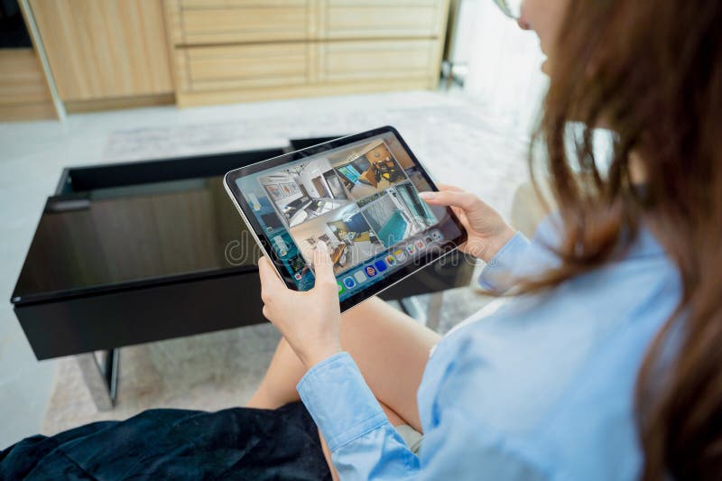 Young Woman Looking at Home Security Cameras on Tablet Computer Stock ...