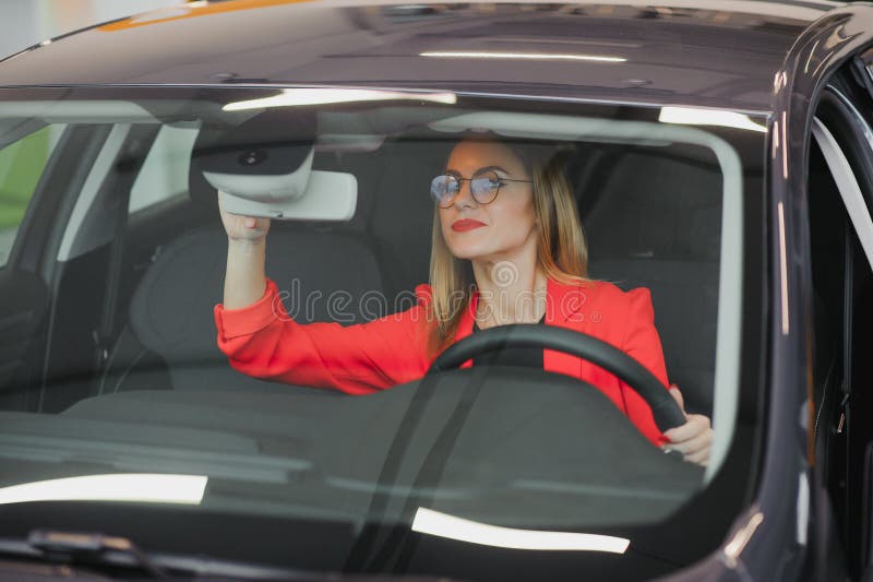 Young Woman Looking in the Rearview Mirror of a Car Stock Photo - Image ...