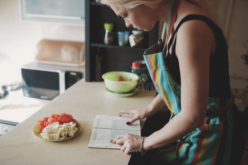 Young Woman Looking Up in a Recipes Book Stock Photo - Image of people ...