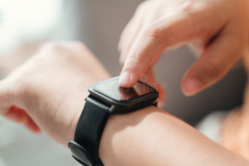 Young Woman Looking and Using a Smartwatch, Female Sitting on the Sofa ...