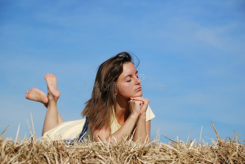 Young woman lying in hay stock image. Image of blue, attractive - 23965547
