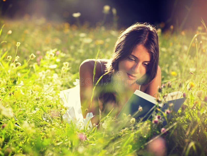 Young Woman Lying In Meadow Reading Book Stock Image Image Of