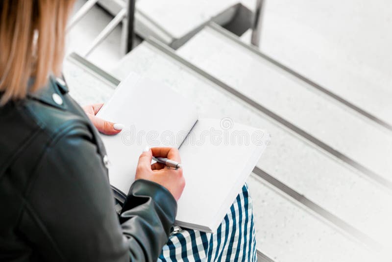 Young Woman Makes Notes in Violet Notepad at Library and Sitting on ...