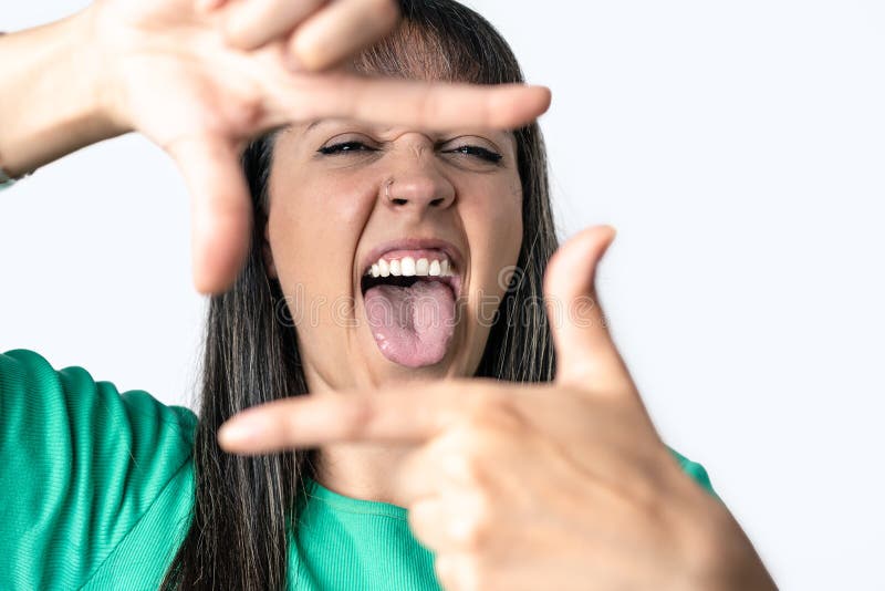 Young Woman Making a Frame with Her Fingers and Sticking Out Her Tongue ... Young Woman Making a Frame with Her Fingers and Sticking Out Her Tongue ...