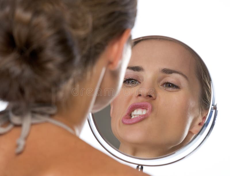 Young Woman Making Funny Faces while Looking in Mirror Stock Photo ...