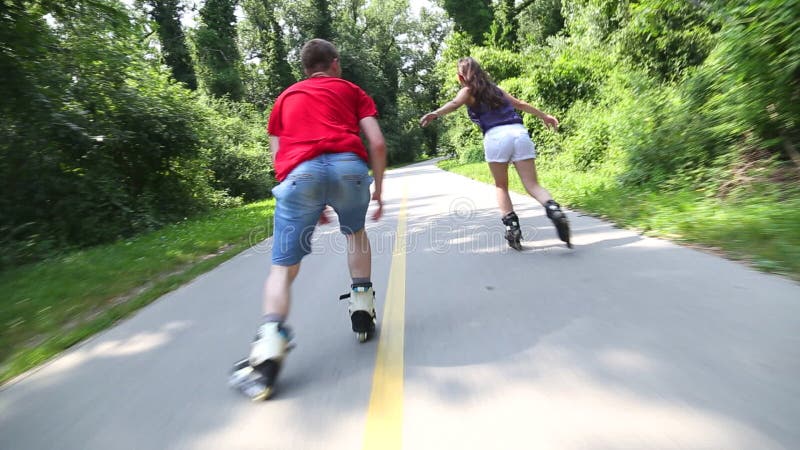 Young Woman and Man Rollerblading and Performing in Park on a Beautiful ...