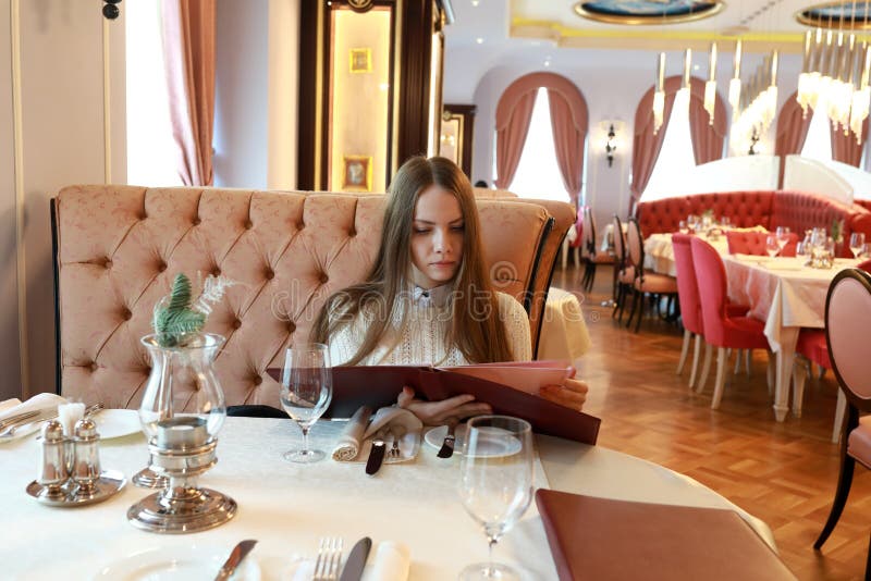 Young woman with menu book stock photo. Image of female - 135041764