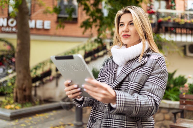 Young Woman Model with a Tablet in Her Hands on the Street in Spring ...