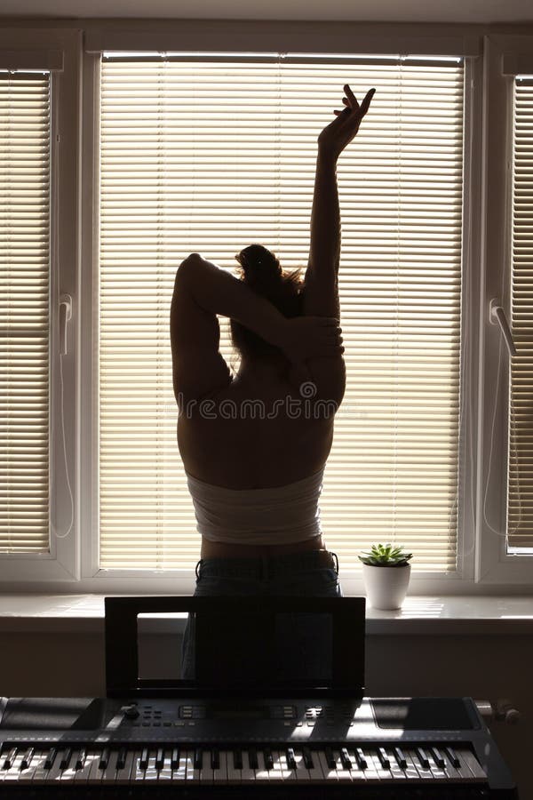 Young Woman Musician Standing at the Window. View from Behind. Stock ...