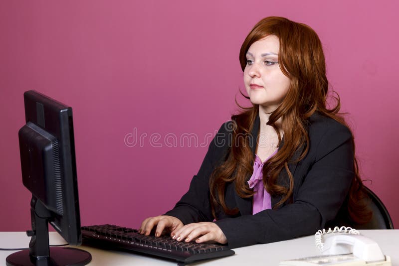 A Young Woman in an Office at a Desk is Typing on a Computer. Stock ...