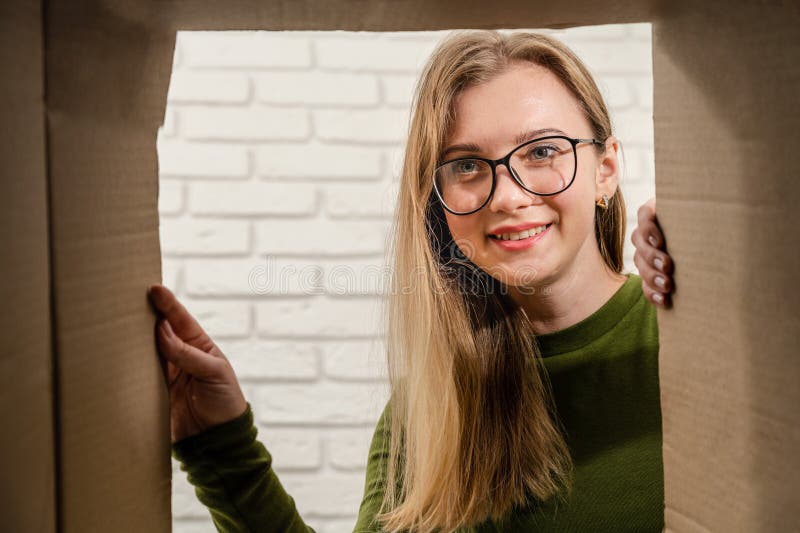 Young Woman Opening Cardboard Box and Looking Inside. Delivering Parcel ...