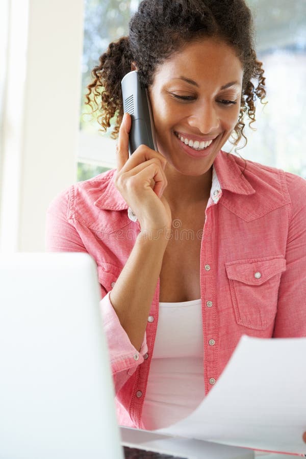 Young Woman on Phone Using Laptop at Home Stock Image - Image of ...