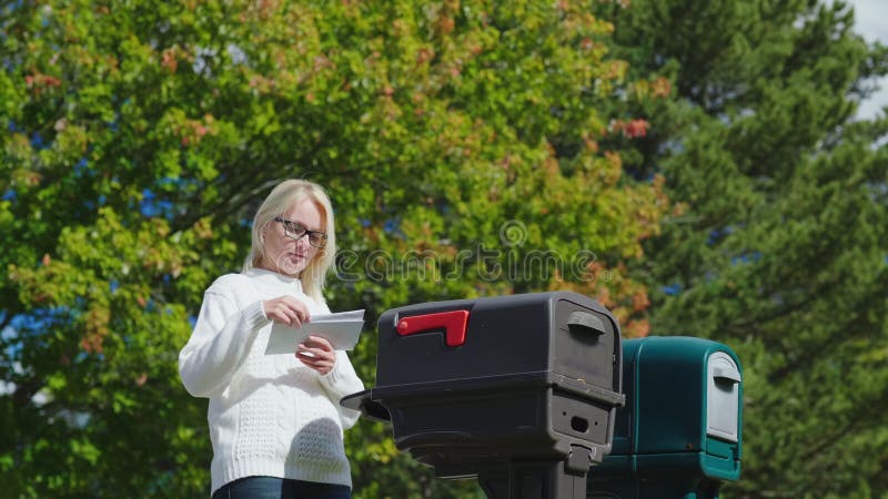 A Young Woman Picks Up Mail from a Outdoors Mailbox Stock Video - Video ...