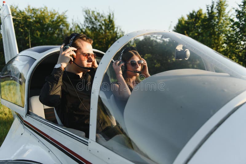 Young Woman and Pilot in in the Cockpit of a Plane. Front View Stock ...