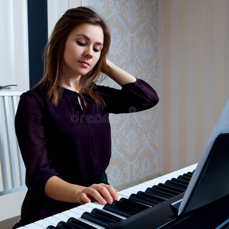 Young Woman Sitting and Playing on the Electronic Piano Stock Photo ...