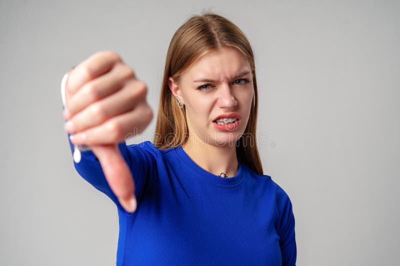 Young Woman Pointing Finger Down at Camera in Studio Stock Photo ...