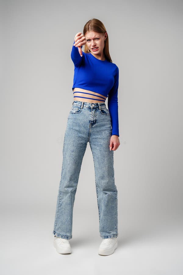 Young Woman Pointing Finger Down at Camera in Studio Stock Photo ...