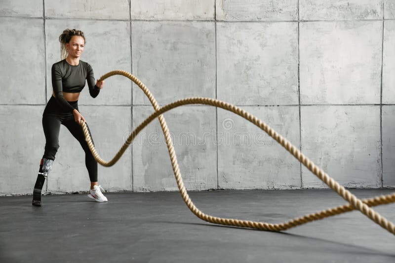 Young Woman with Prosthesis Using Battle Ropes while Working Out Stock ...