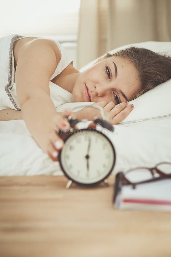 A Young Woman Putting Her Alarm Clock Off in the Morning. Stock Image ...