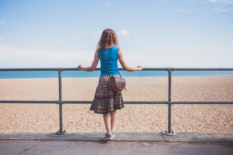 Young Woman by Railing on the Beach Stock Image - Image of beach, woman ...