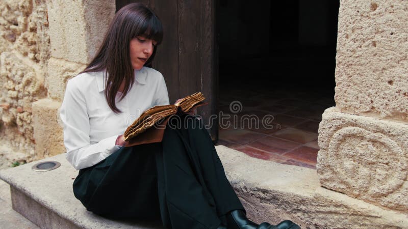 Young Woman Reading an Ancient Book with Passion Sitting on a Building ...