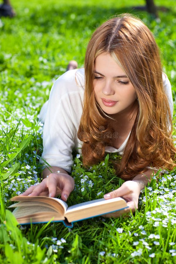 Young woman reading book stock photo. Image of grass - 14490676