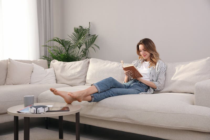 Young Woman Reading Book on Sofa Stock Image - Image of caucasian ...