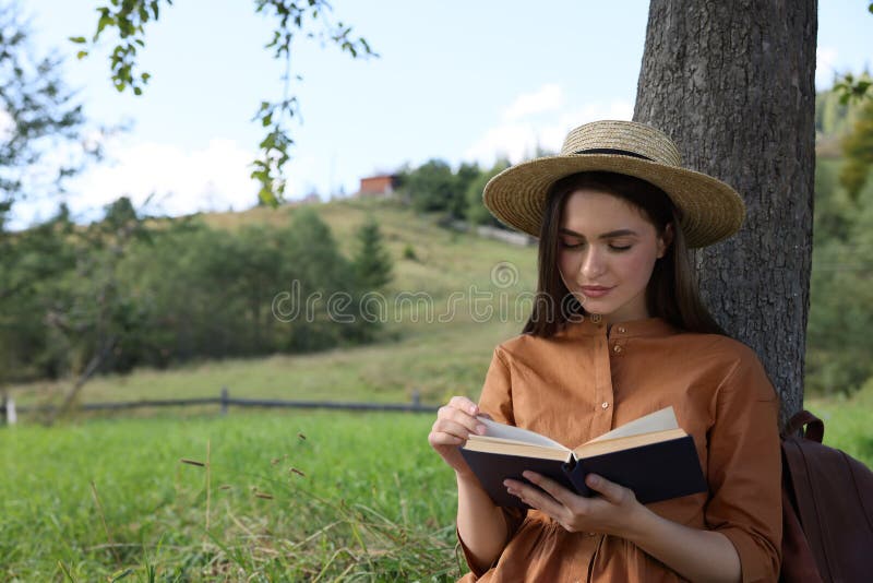 Young Woman Reading Book Under Tree on Meadow Stock Photo - Image of ...