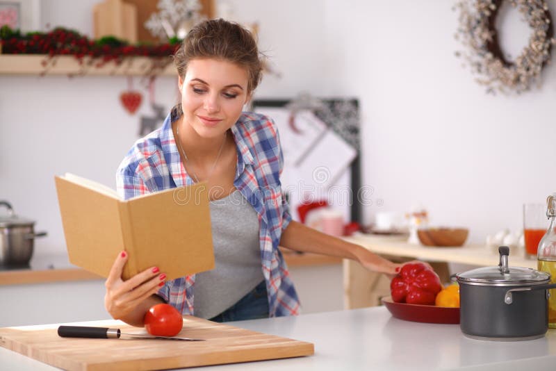 Young Woman Reading Cookbook in the Kitchen, Stock Photo - Image of ...