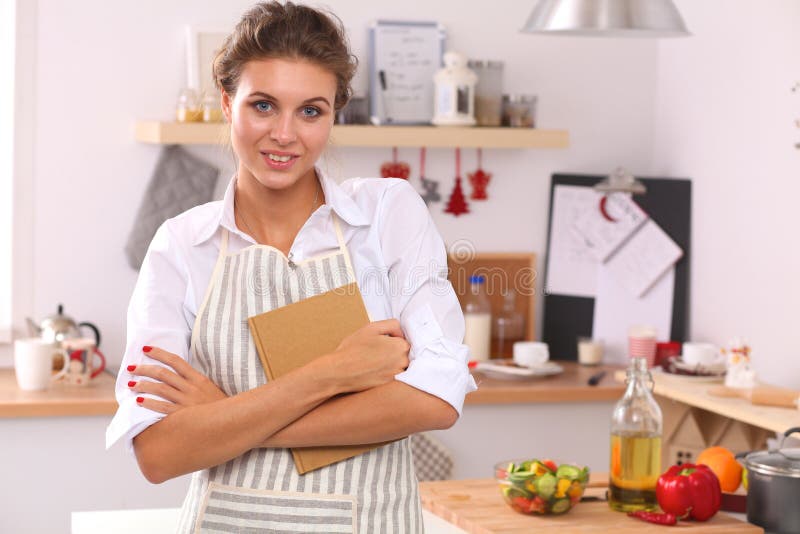 Young Woman Reading Cookbook in the Kitchen, Looking for Recipe Stock ...