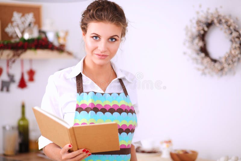 Young Woman Reading Cookbook in the Kitchen, Looking for Recipe Stock ...