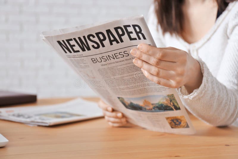 Young Woman Reading Newspaper at Table Indoors Stock Image - Image of ...