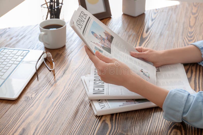 Young Woman Reading Newspaper at Table Indoors Stock Photo - Image of ...