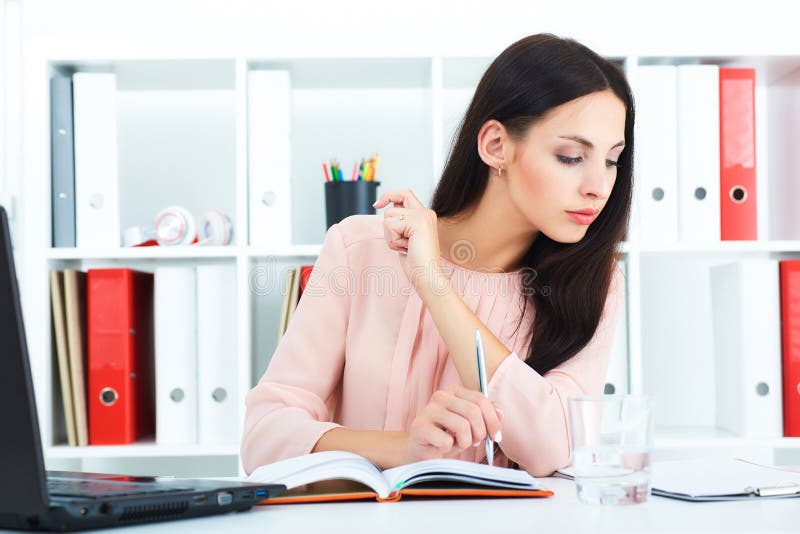 Young Woman Reading Papers Sitting on Her Workplace. Stock Image ...