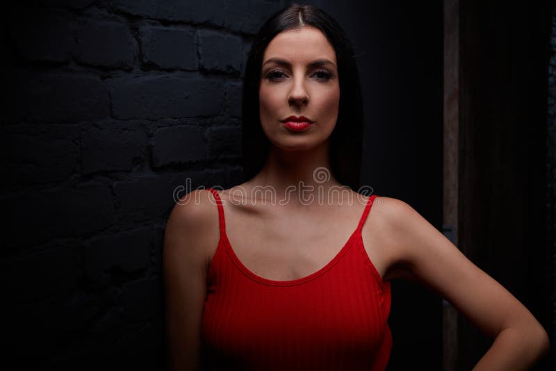 Young Woman in Red Against Black Wall Stock Image - Image of long ...