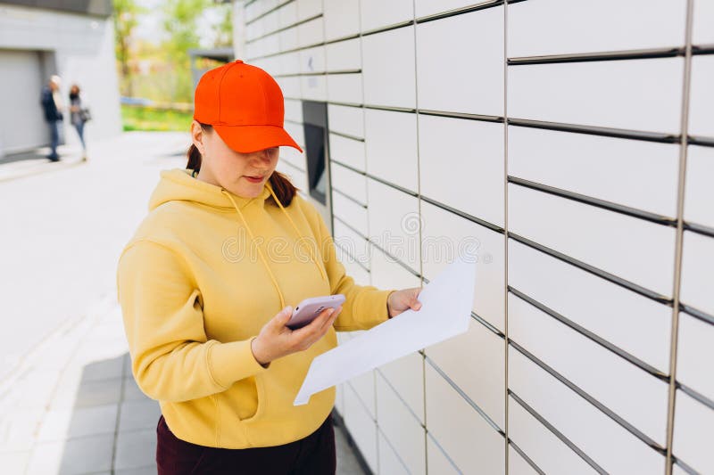 Young Woman in Red Hat Picks Up Parcel from Automatic Post Office ...