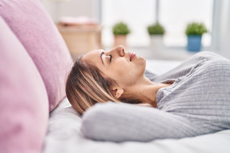 Young Woman Relaxed with Hands on Head Lying on Bed at Bedroom Stock ...