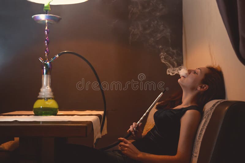 A Young Woman Relaxing on the Couch Smoking a Hookah Stock Photo ...