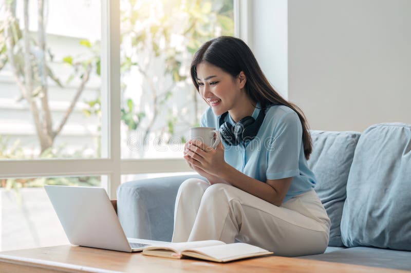 Young Woman Relaxing and Drinking Cup of Hot Coffee or Tea Using Laptop ...